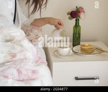 Girl in bed, coffee, breakfast flowers, romance and good morning. Copy ...