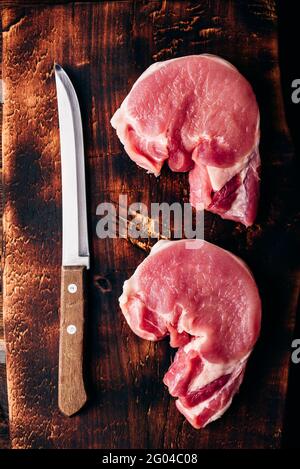 Two pork loin steaks with knife on rustic cutting board Stock Photo - Alamy
