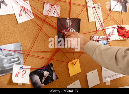Detective board with crime scene photos, stickers, clues and red thread ...