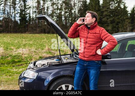 Man calling repair service after car breakdown.youg man talking on cell ...
