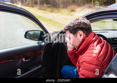 Man calling repair service after car breakdown.youg man talking on cell ...