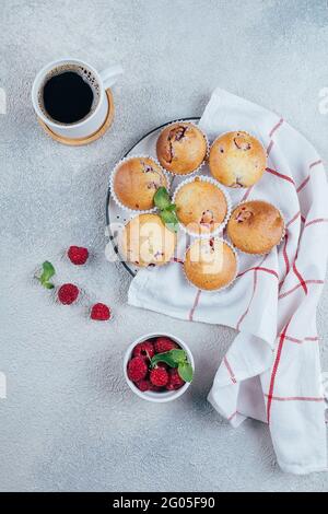 Cup of black coffee, raspberry muffins on concrete table. Top view ...
