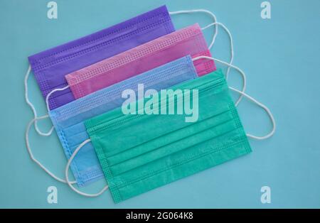 High angle shot of multicolored medical face mask isolated over blue ...