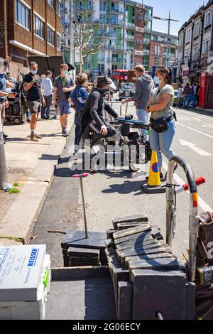 Film crew in Peckham Rye street in south London filming with Director ...