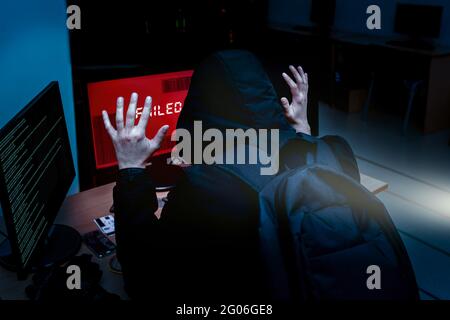 Arrested computer hacker and cyber criminal with handcuffs wearing ...