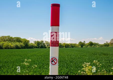 Red and white striped warning poles for the presence of buried gas pipe ...