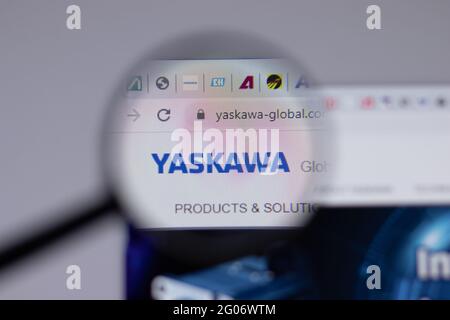 Yaskawa company logo on a website with blurry stock market graphs in ...