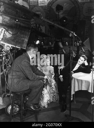 TYRONE POWER on set candid with wardrobe expert EDDIE ARMAND on set ...