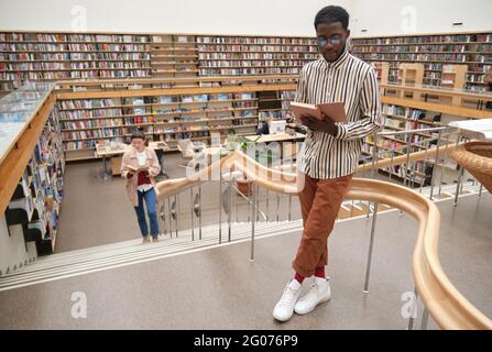 Smiling young working man standing with new auto tires for in hands in ...