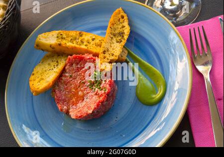 Image of delicious veal steak tartar served at plate with fried bread ...