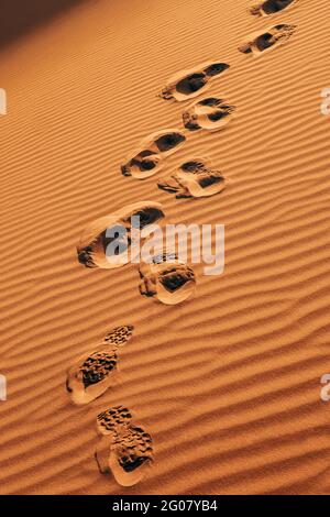From above of footsteps on texture of brown sand in hot desert in ...