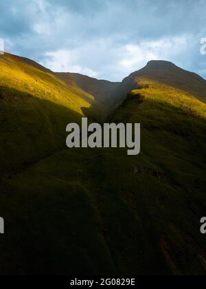 Overcast sundown sky over hill slope and curvy river in peaceful ...