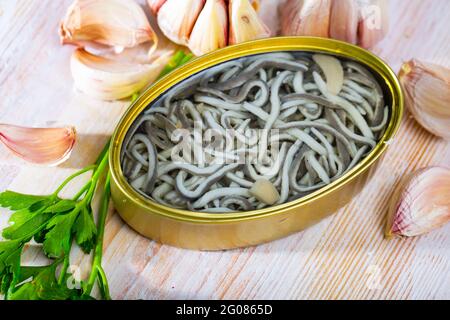Tasty pickled eels on background garlic and greens at table Stock Photo ...