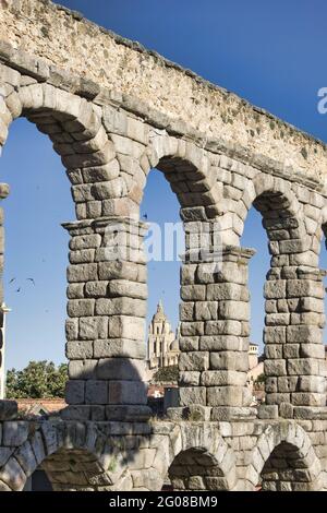 Vertical shot of The Aqueduct of Segovia under a blue sky and sunlight ...