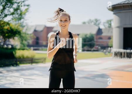 Positive active female in activewear practicing Swan pose on hammock ...