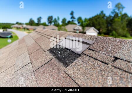 Wind damaged house roof with missing asphalt shingles after hurricane ...