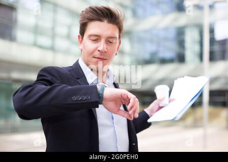 Businessman hurrying to meeting and watching on wristwatch Stock Photo ...