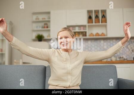 An elderly woman experiences the joy of being at home with her arms ...