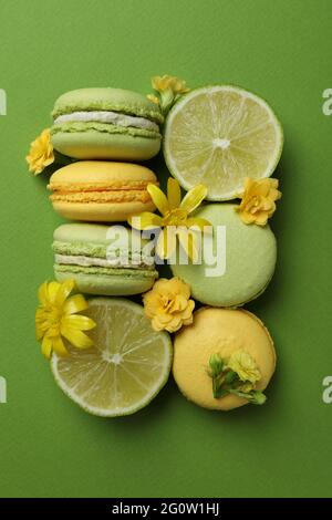Macaroons, limes and flowers on green background Stock Photo - Alamy