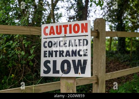 Sign warning, SLOW concealed entrance Stock Photo - Alamy