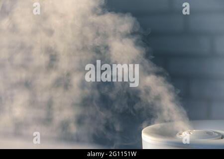 Humidifier spreading steam with white brick wall background. Loft style ...