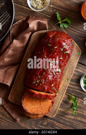 Meatloaf with glaze on cutting board over wooden background with free ...