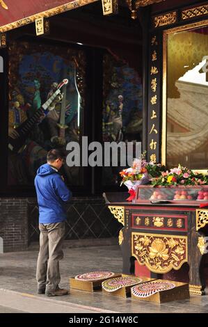 An ethnic Chinese man prays with incense sticks at Johor Ancient Temple ...