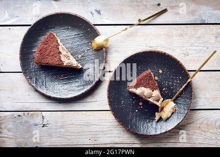 Two pieces of chocolate cake on black plates, top view Stock Photo - Alamy