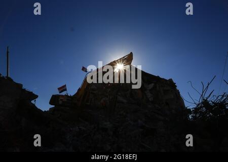 Palestinian workers clear the rubble of Al-Jawhara Tower building that ...
