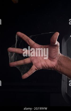 A man fingers covered with spider web on black background Stock Photo ...