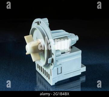 Washing machine pump on blue table with reflection. Equipment on a ...