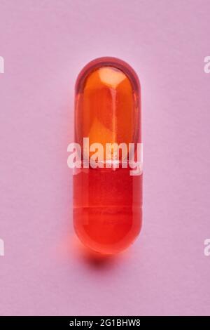 Composition of orange pills on pink background in light studio Stock ...