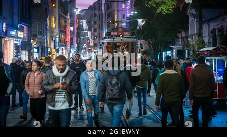 People crowd walking through Istiklal Avenue which is the most famous ...