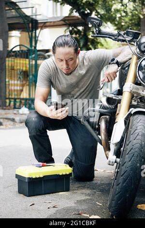 Serious young man fixing mobile phone free space Stock Photo - Alamy