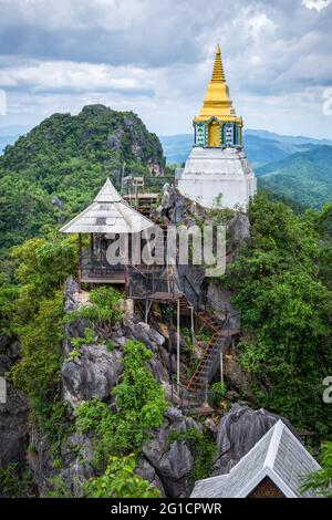 White pagoda and stupa on top of mountain cliff in woodland called Wat ...