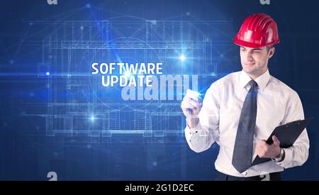 Handsome architect with helmet drawing SOFTWARE UPDATE inscription, new ...