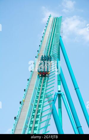 Moving roller coaster in an amusement park during the summer daytime ...