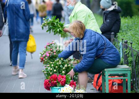 Old women flower sellers sell flowers on the street of the city, people ...
