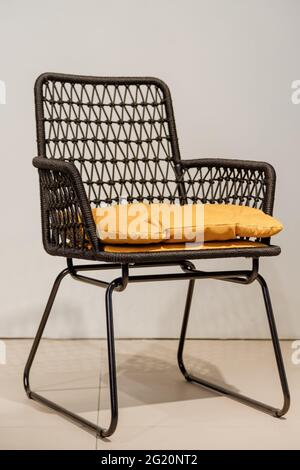Black wicker chair with yellow pillows. Details Stock Photo - Alamy
