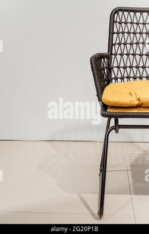 Black wicker chair with yellow pillows. Details Stock Photo - Alamy