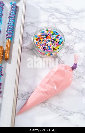 Drizzling melted pink chocolate on top of the mini chocolates and ...