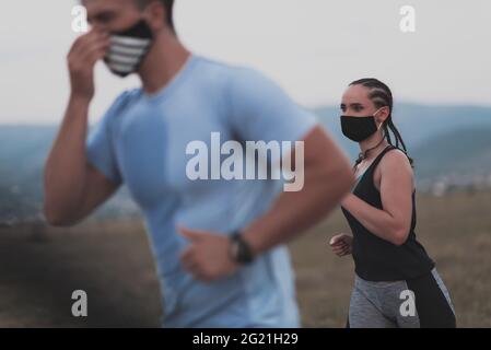 Three multiethnic women runners group wear face masks running keep ...
