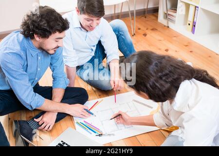 Architects or civil engineers bent over construction plans on the ...