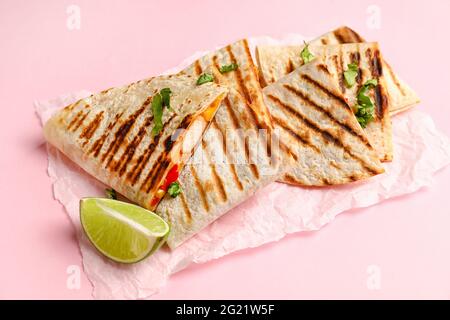 Parchment with tasty quesadillas and lime on color background Stock ...