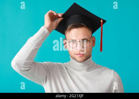 Male graduating student on color background Stock Photo - Alamy