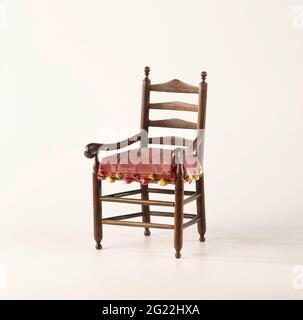 Resting on a chair turned backwards, this female teen smiles with her ...