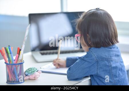 Cute children doing homework with laptop Stock Photo - Alamy