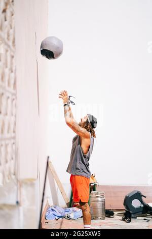 Fit man throwing medicine ball doing ball slam against gym floor or ...