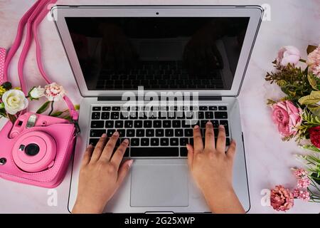 Laptop with a pink photo camera and an album and flowers Stock Photo ...