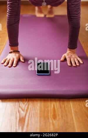 Online yoga practice. Mature asian man doing butterfly asana on sports ...